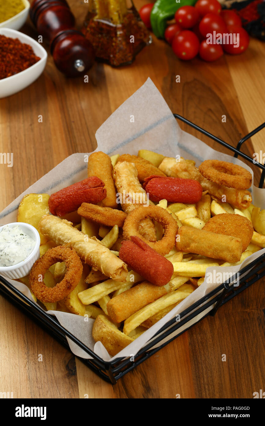 Mixed appetizer of french fries, fried sasusage, fried zucchini, pastry ...