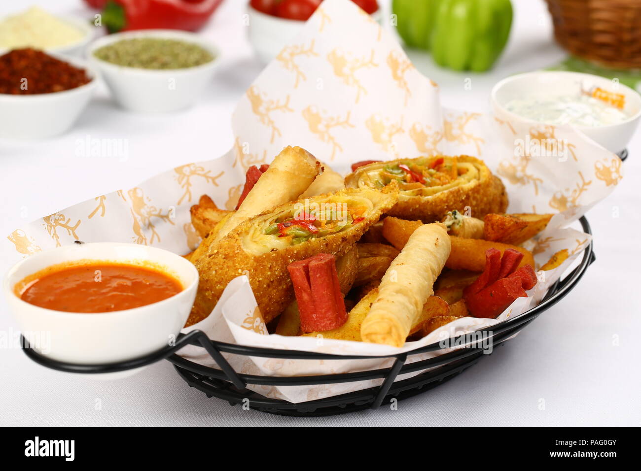 Mixed appetizer of french fries, fried sasusage, fried zucchini, pastry ...