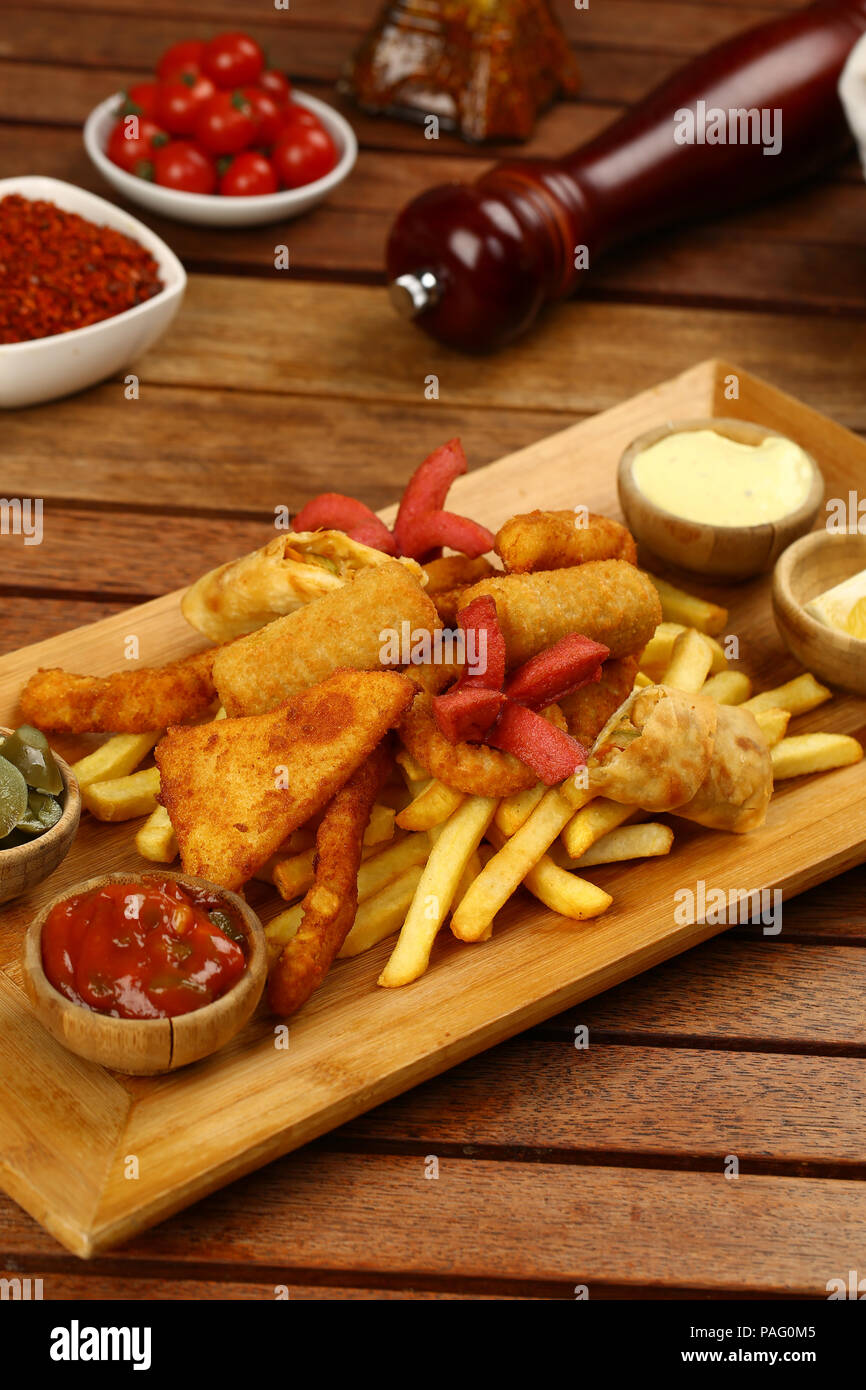 Mixed appetizer of french fries, fried sasusage, fried zucchini, pastry ...