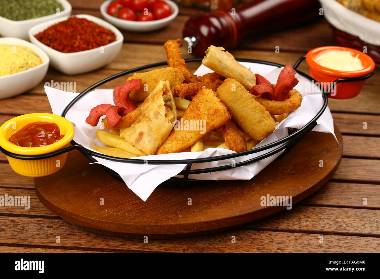 Mixed appetizer of french fries, fried sasusage, fried zucchini, pastry ...