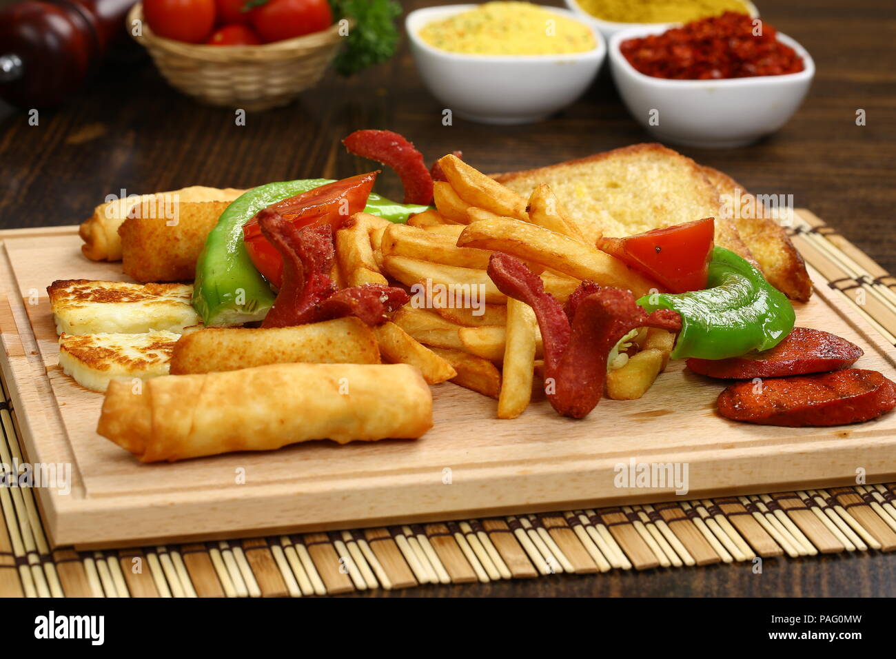 Mixed appetizer of french fries, fried sasusage, fried zucchini, pastry ...