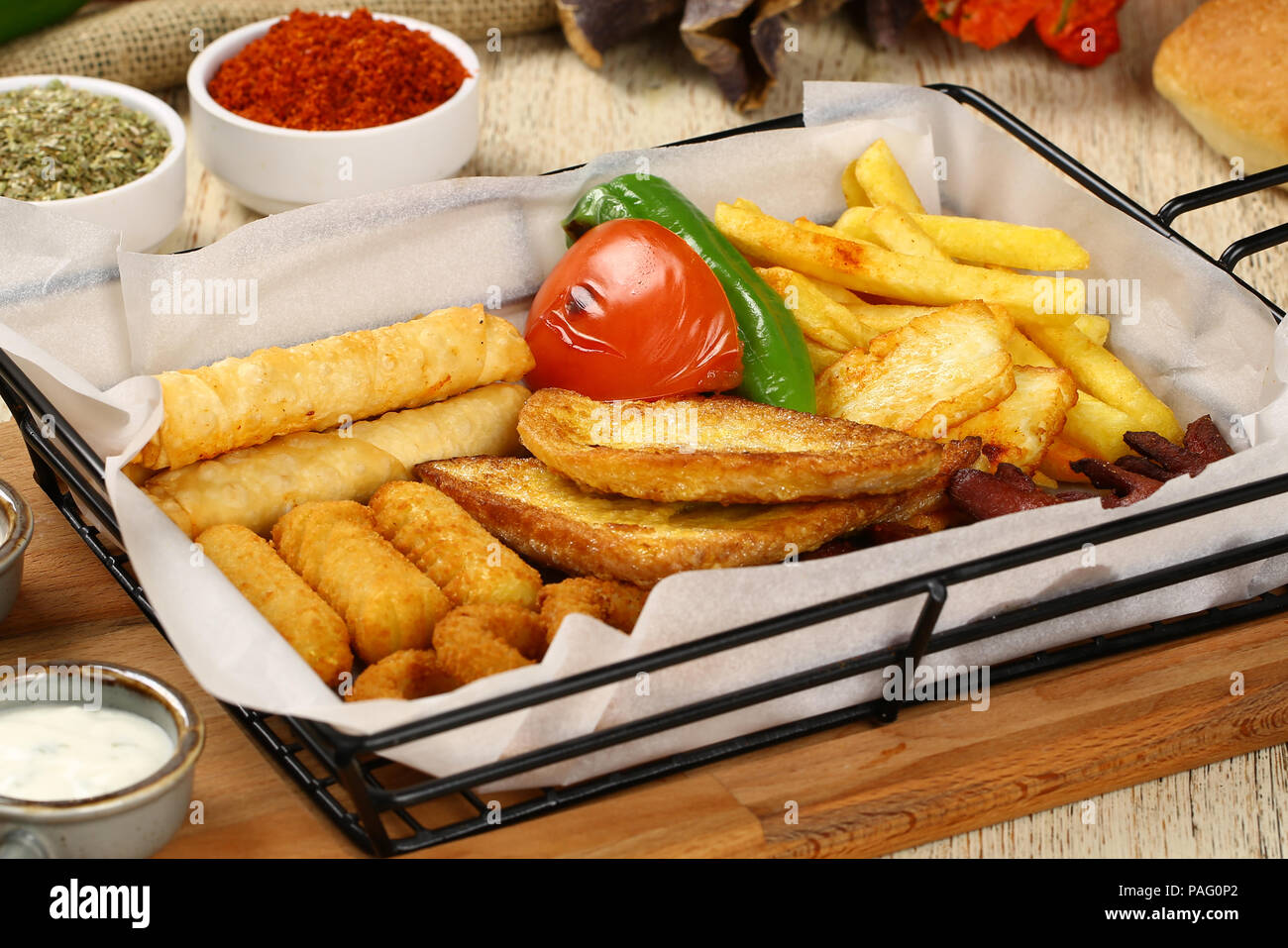 Mixed appetizer of french fries, fried sasusage, fried zucchini, pastry ...