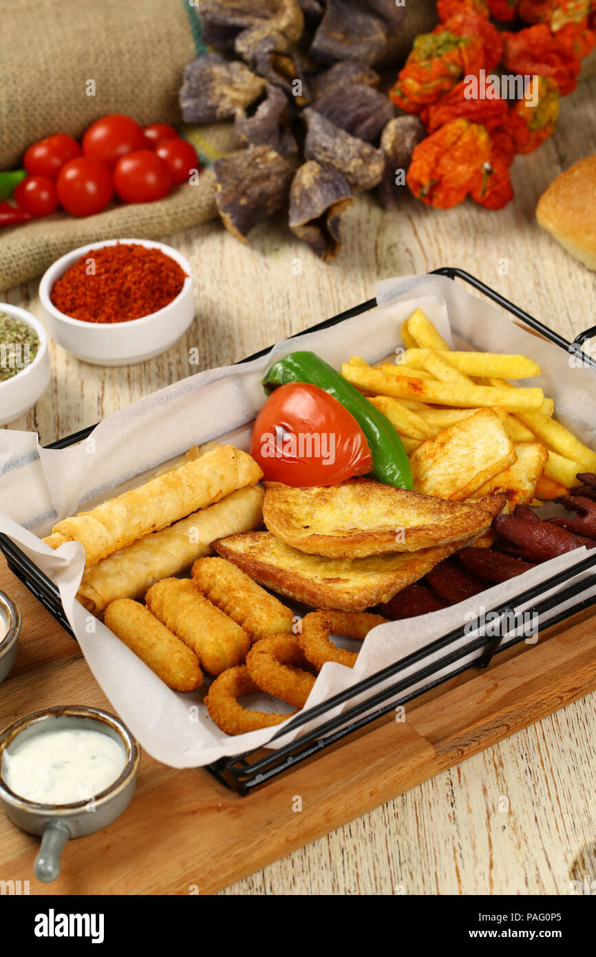 Mixed appetizer of french fries, fried sasusage, fried zucchini, pastry ...