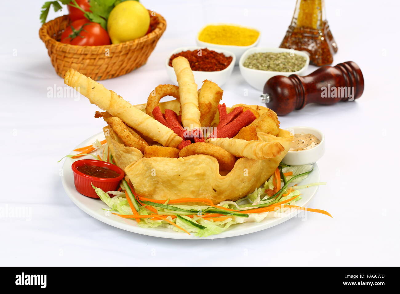 Mixed appetizer of french fries, fried sasusage, fried zucchini, pastry ...