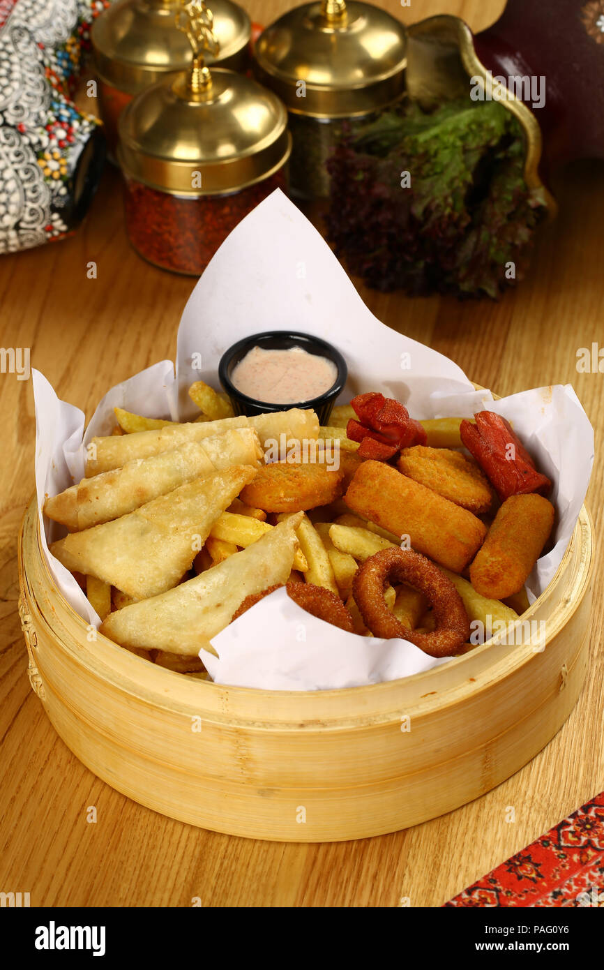 Mixed appetizer of french fries, fried sasusage, fried zucchini, pastry ...