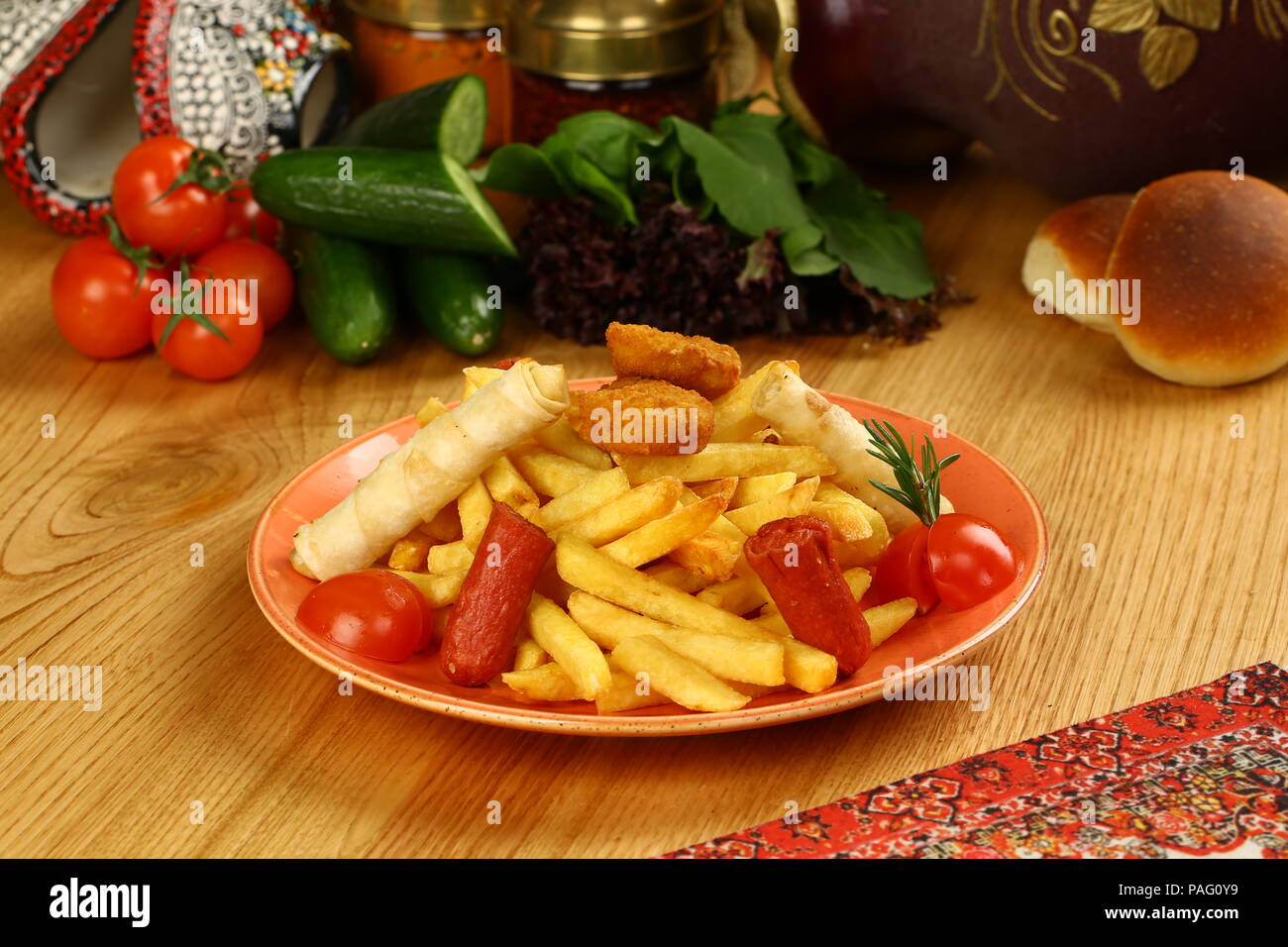 Mixed appetizer of french fries, fried sasusage, fried zucchini, pastry ...