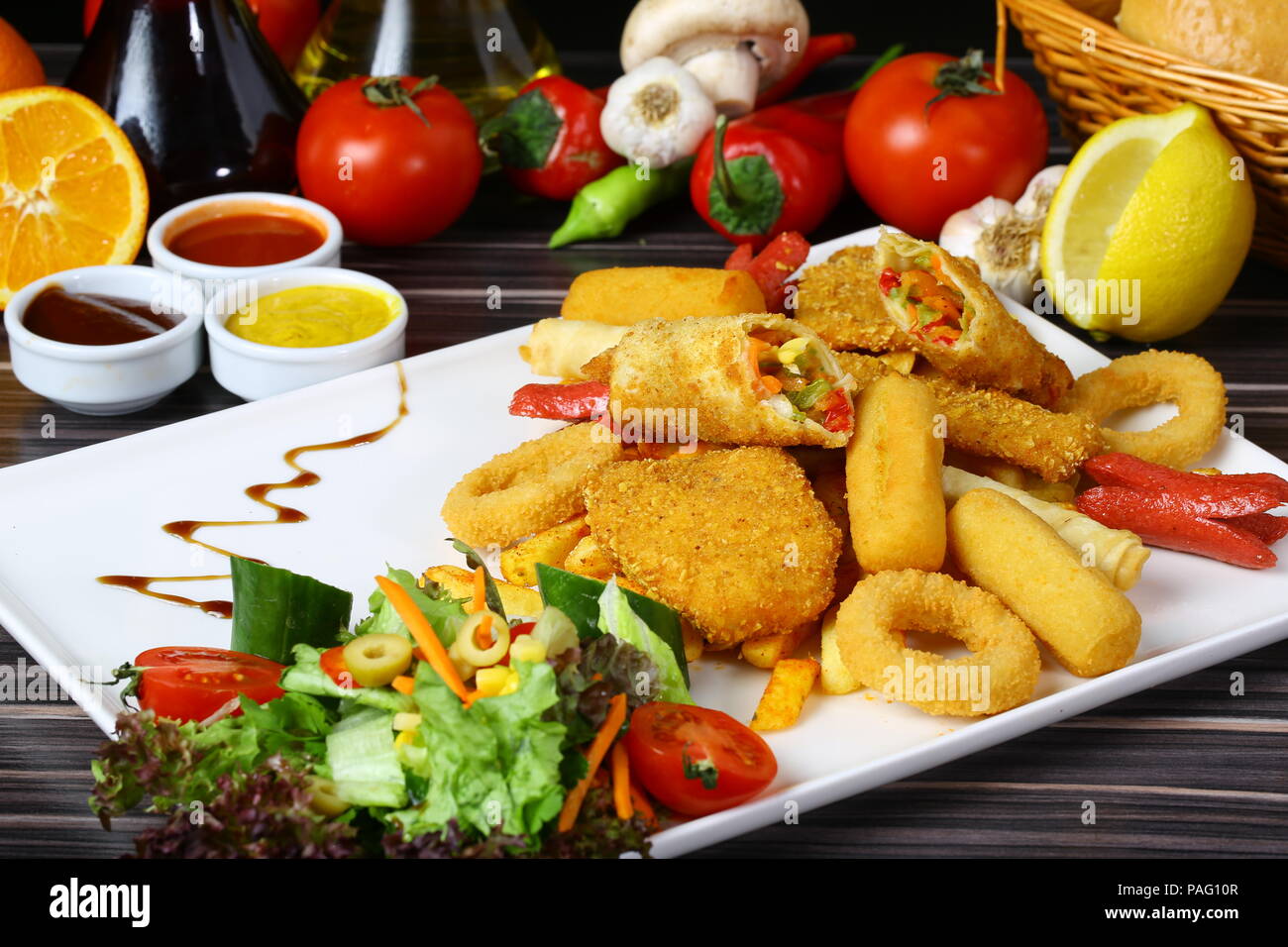 Mixed appetizer of french fries, fried sasusage, fried zucchini, pastry ...