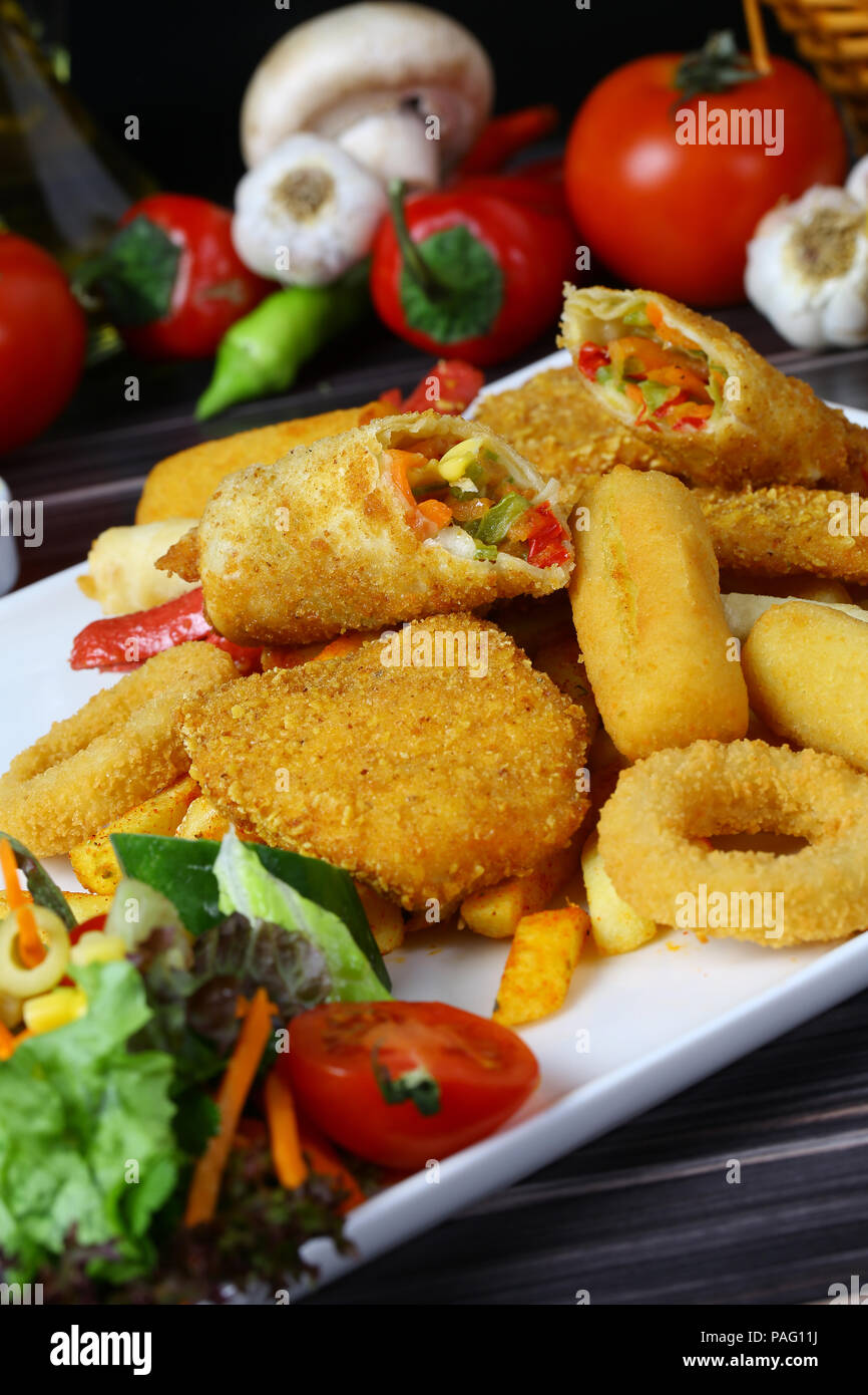Mixed appetizer of french fries, fried sasusage, fried zucchini, pastry ...
