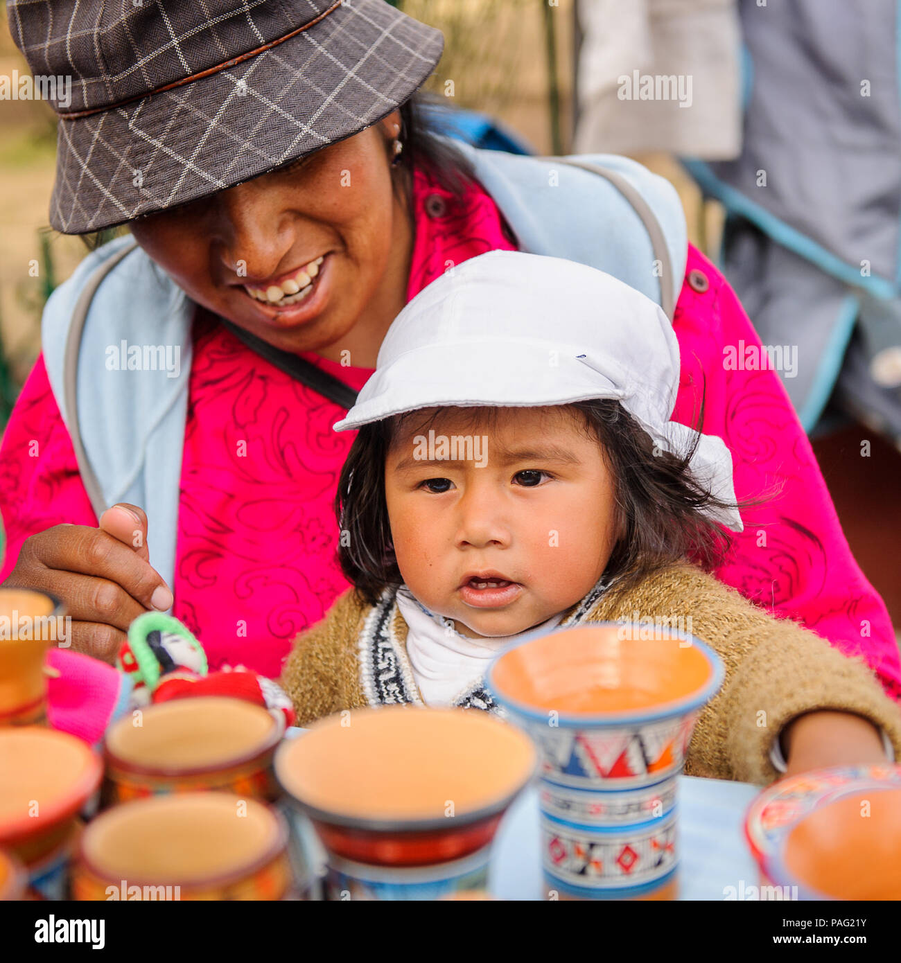 PERU - NOVEMBER 7, 2010: Undientified Peruvian girl helps her mother to ...