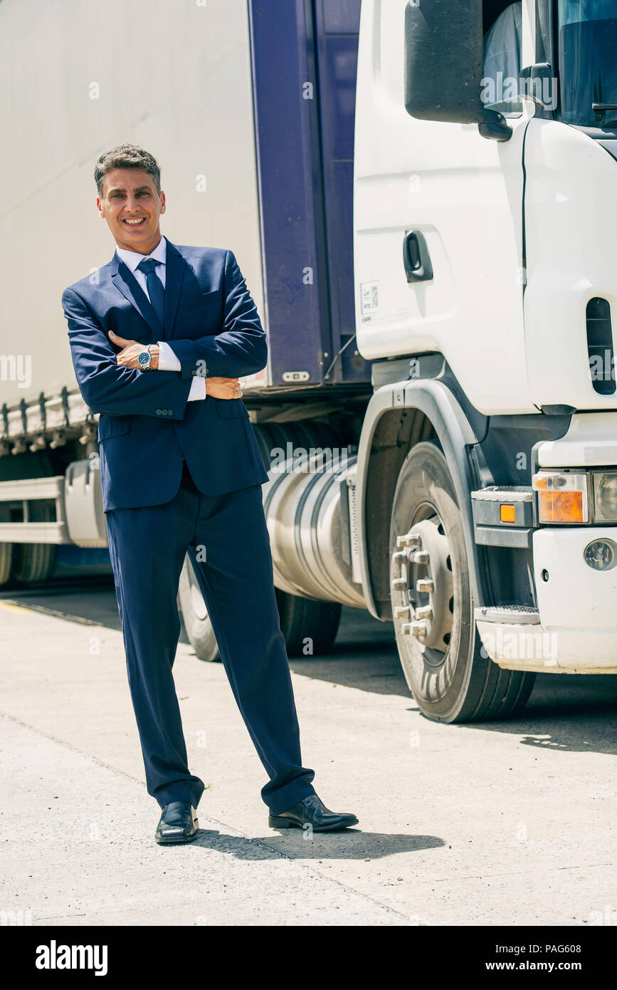 Businessman standing in front of lorry Stock Photo - Alamy