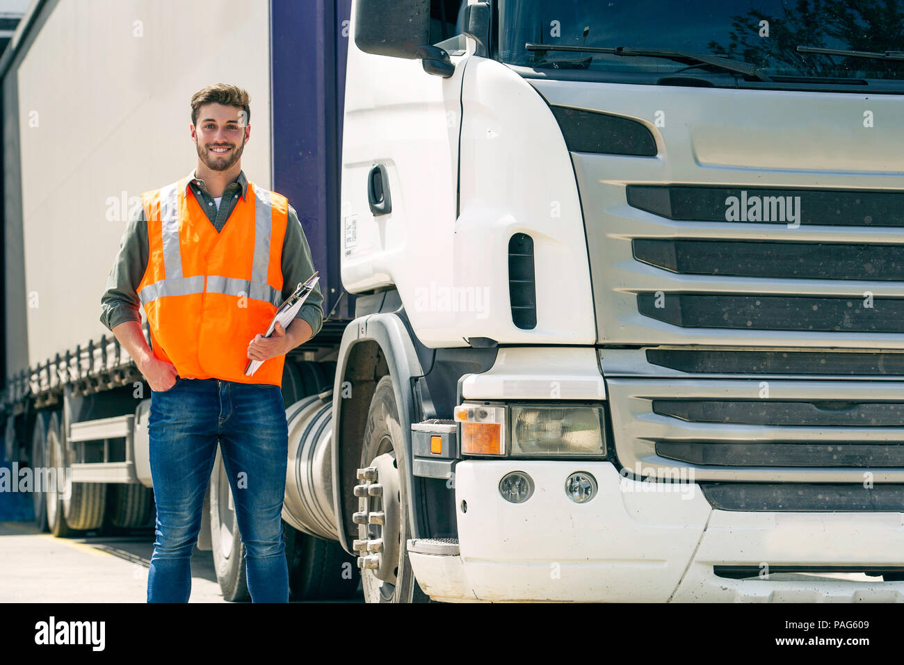 Worker standing in front of lorry Stock Photo - Alamy