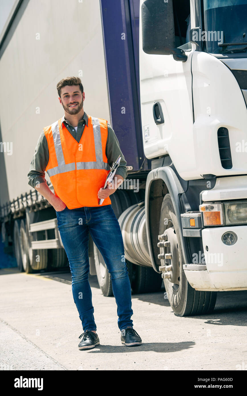 Worker standing in front of lorry Stock Photo - Alamy
