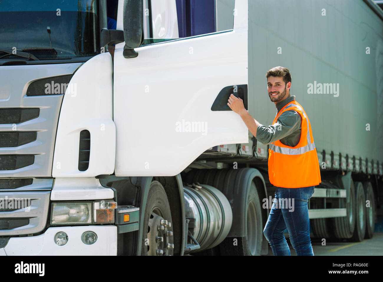 Worker opening door of lorry Stock Photo - Alamy