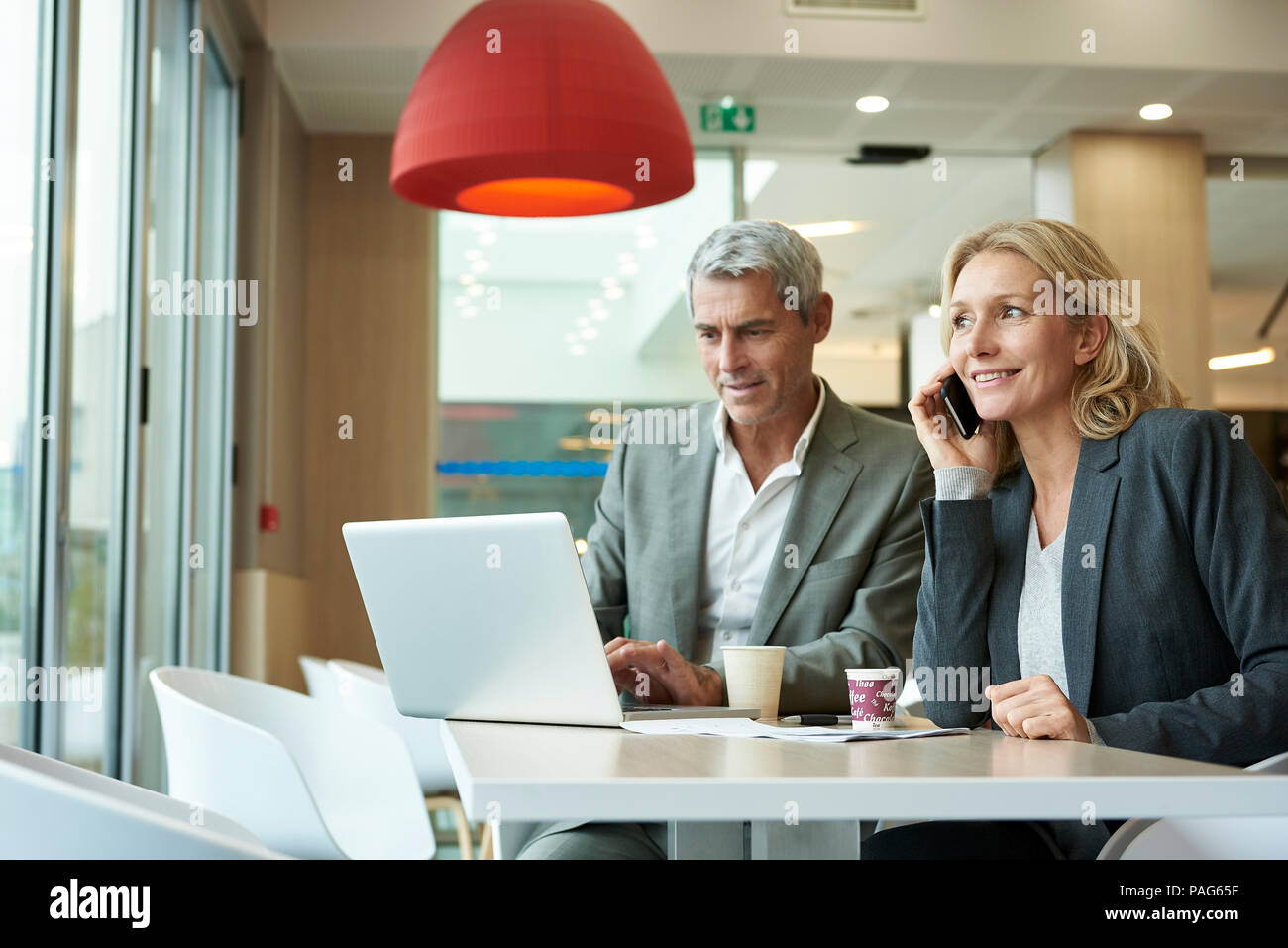 Businesspeople working in cafeteria Stock Photo - Alamy