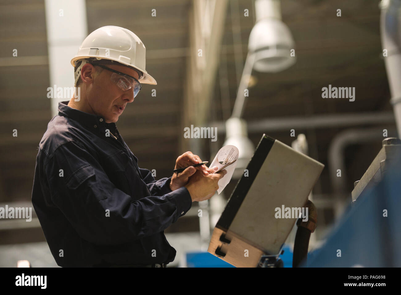 Factory worker examining control panel Stock Photo - Alamy