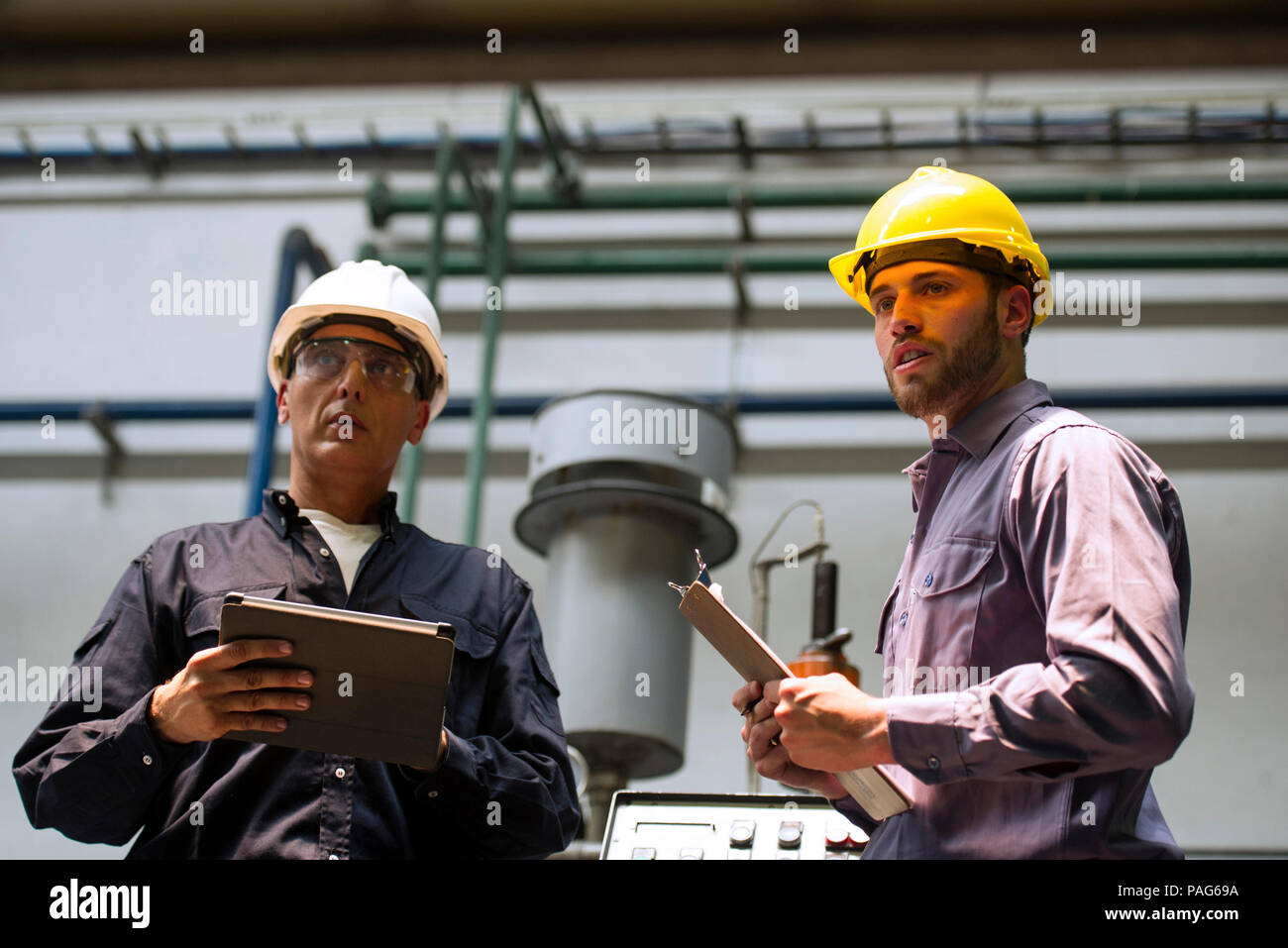 Factory workers with digital tablet and clipboard in factory Stock ...