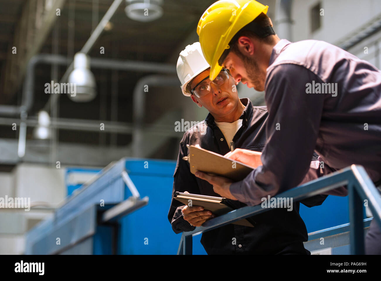 Factory workers discussing with each other in factory Stock Photo - Alamy