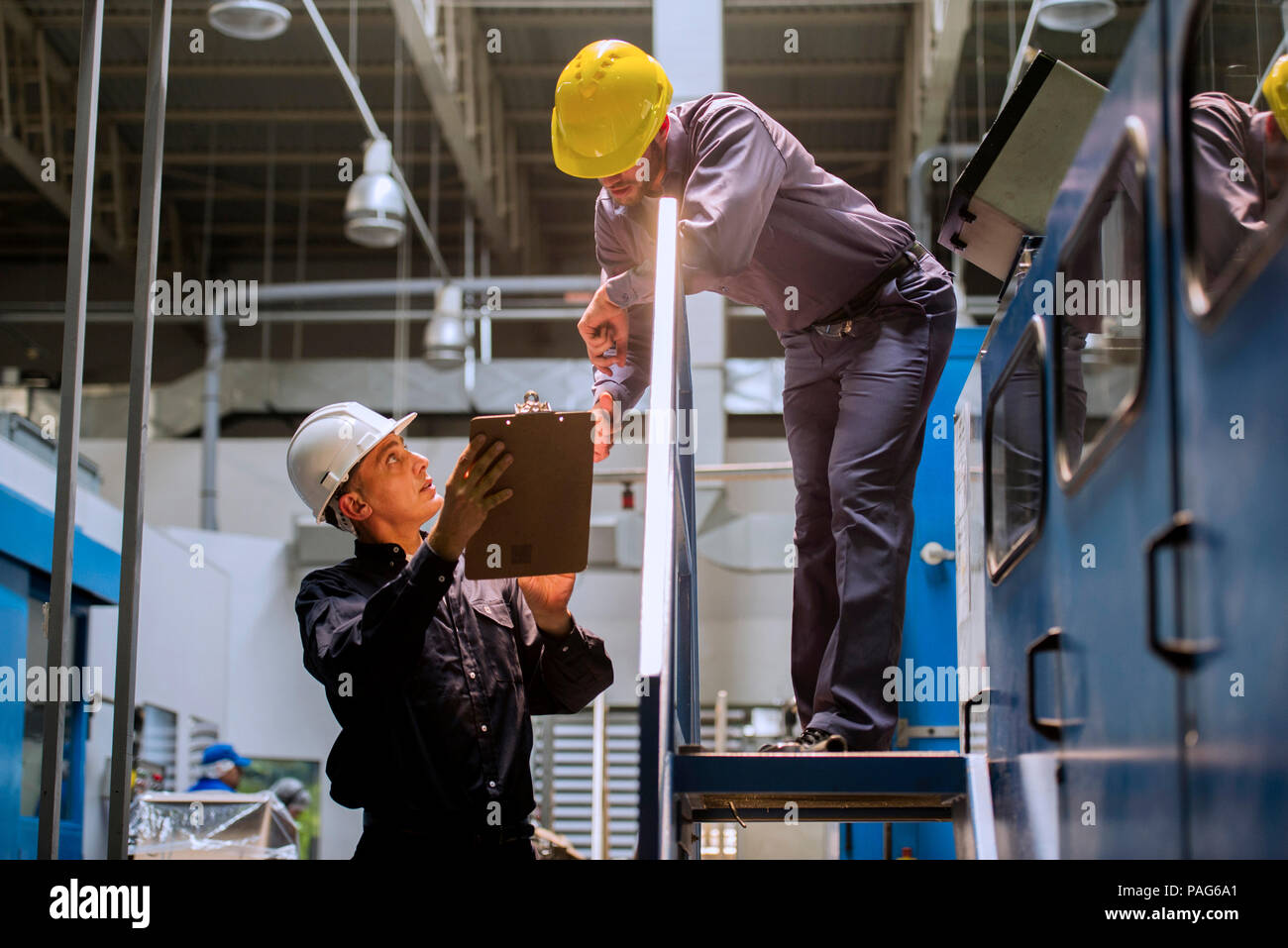Factory workers with clipboard in factory Stock Photo - Alamy