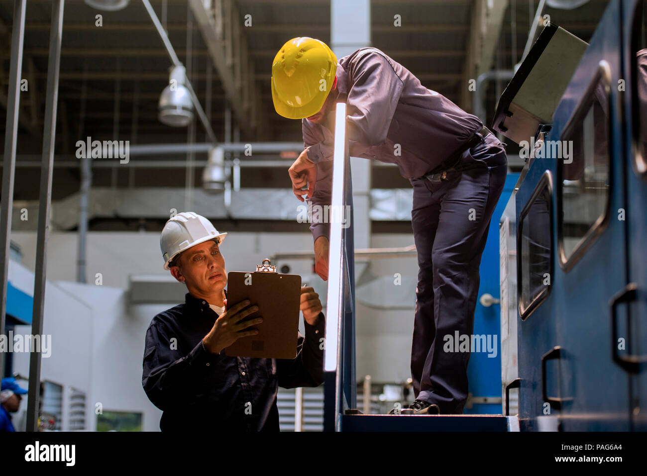 Factory workers with clipboard in factory Stock Photo - Alamy