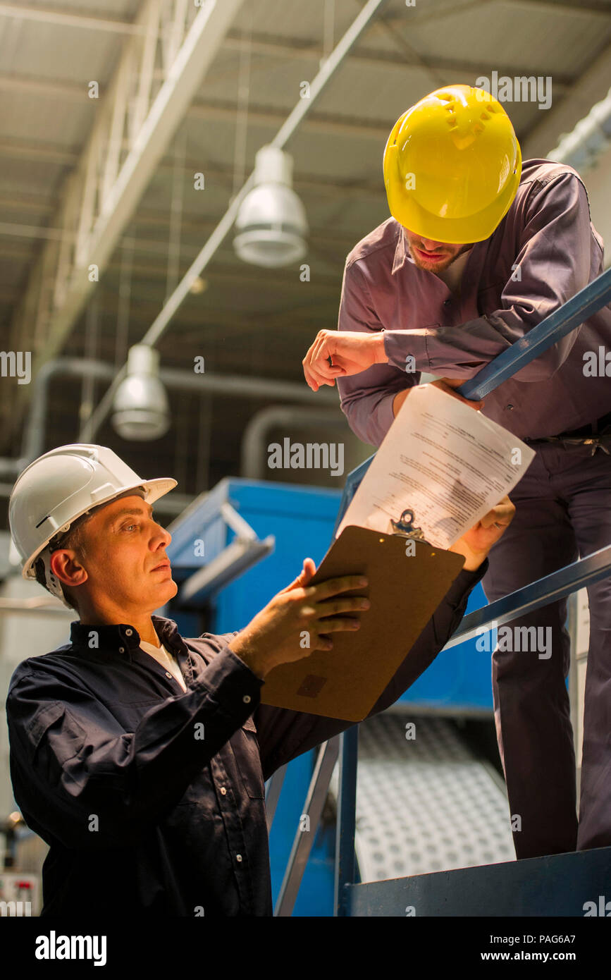 Factory workers with clipboard in factory Stock Photo - Alamy