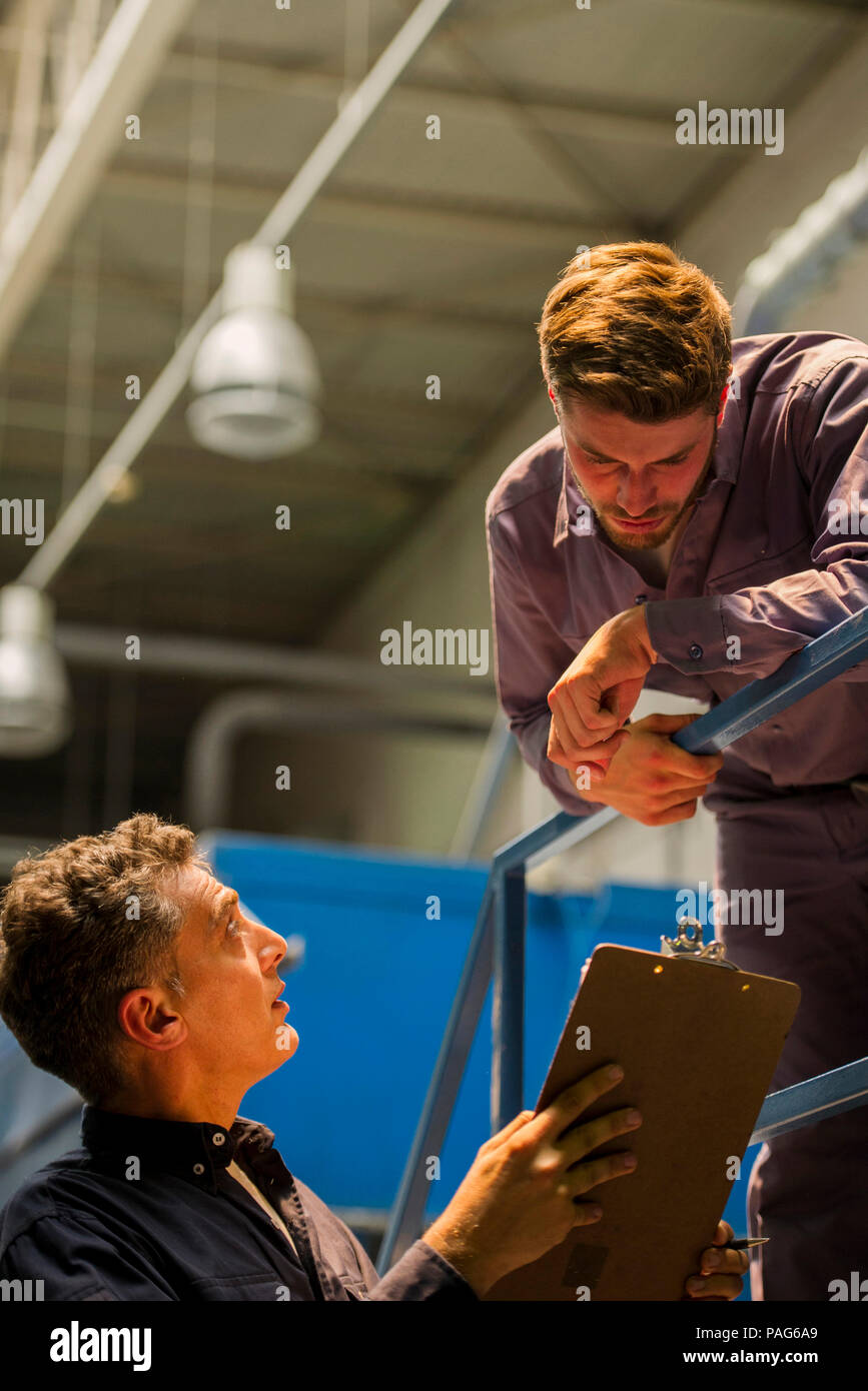 Factory workers with clipboard in factory Stock Photo - Alamy