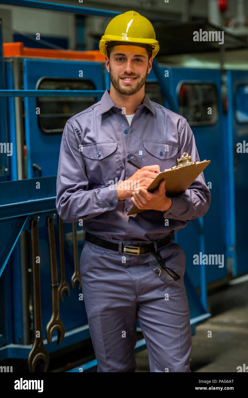 Factory worker with clipboard in factory Stock Photo - Alamy