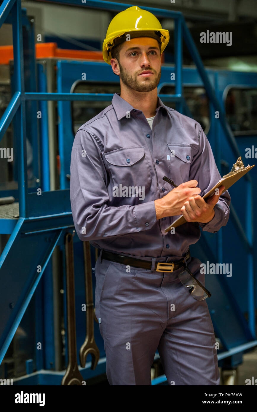 Factory worker with clipboard in factory Stock Photo - Alamy