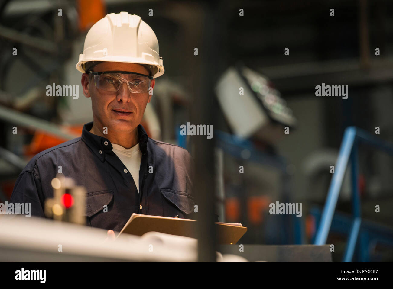Factory worker with clipboard in factory Stock Photo - Alamy
