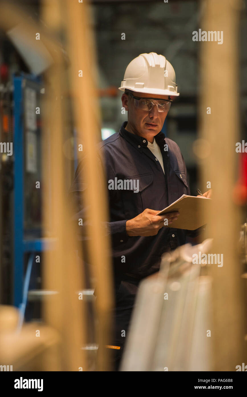 Factory worker with clipboard in factory Stock Photo - Alamy