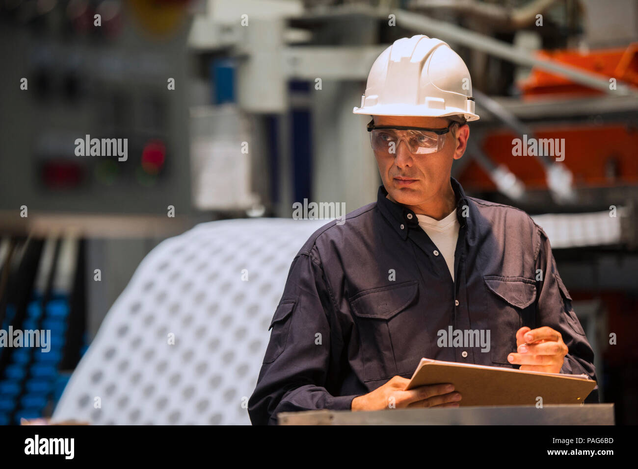 Factory worker with clipboard in factory Stock Photo - Alamy