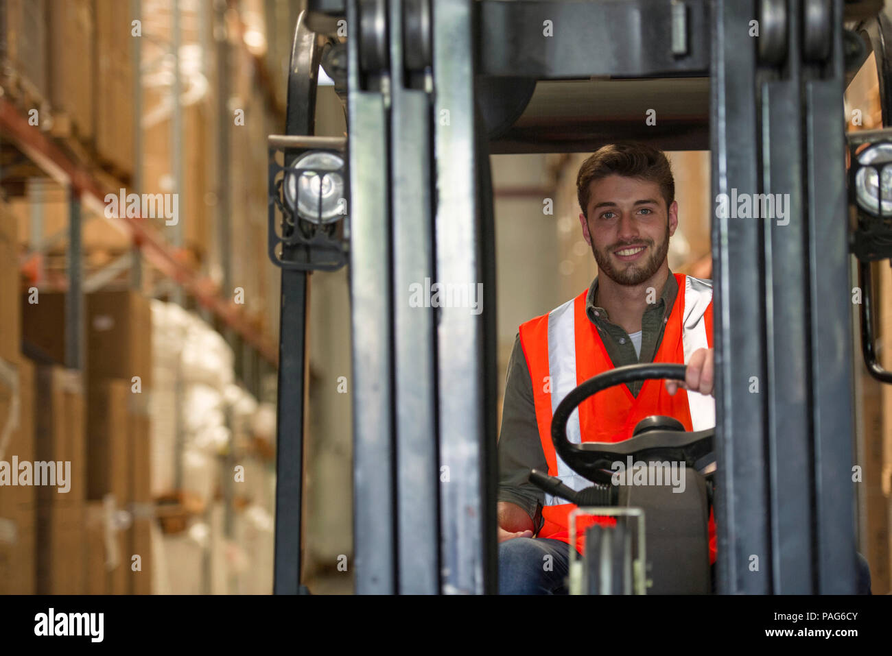 Worker operating forklift truck Stock Photo - Alamy
