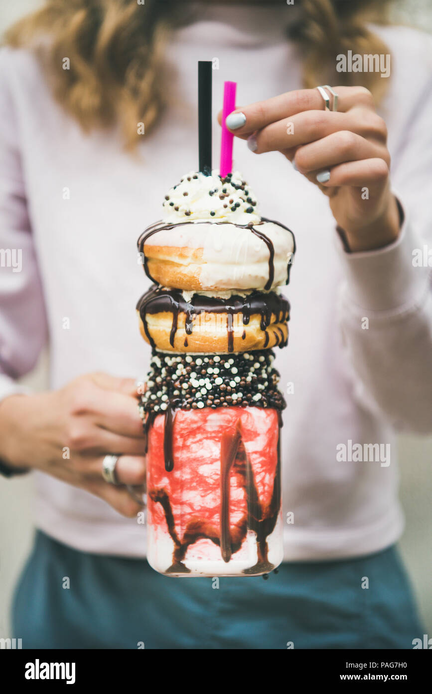 Girl holding cold strawberry freakshake in hands Stock Photo - Alamy