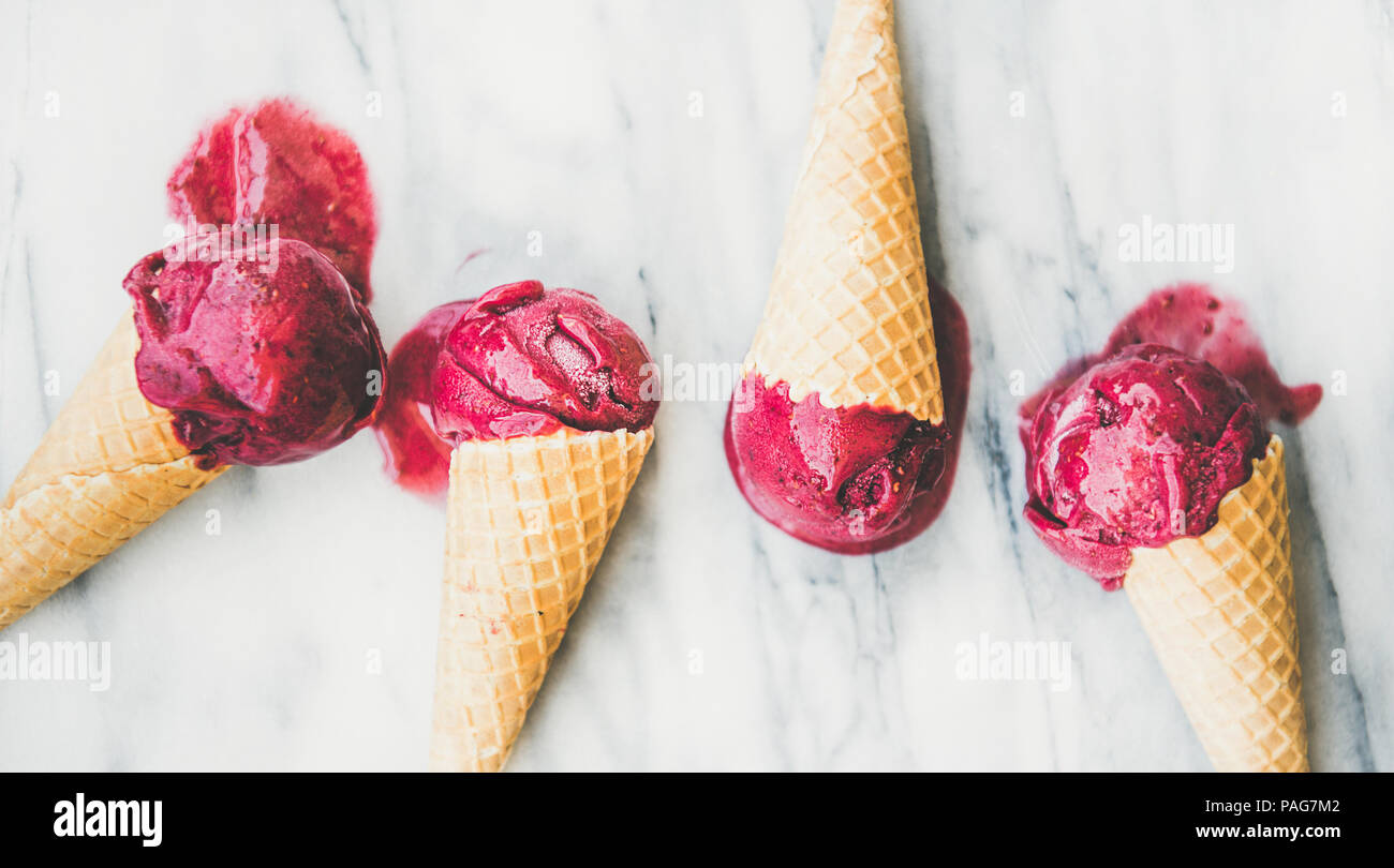 Melting natural raspberry sorbet ice-cream scoops in sweet waffle cones ...