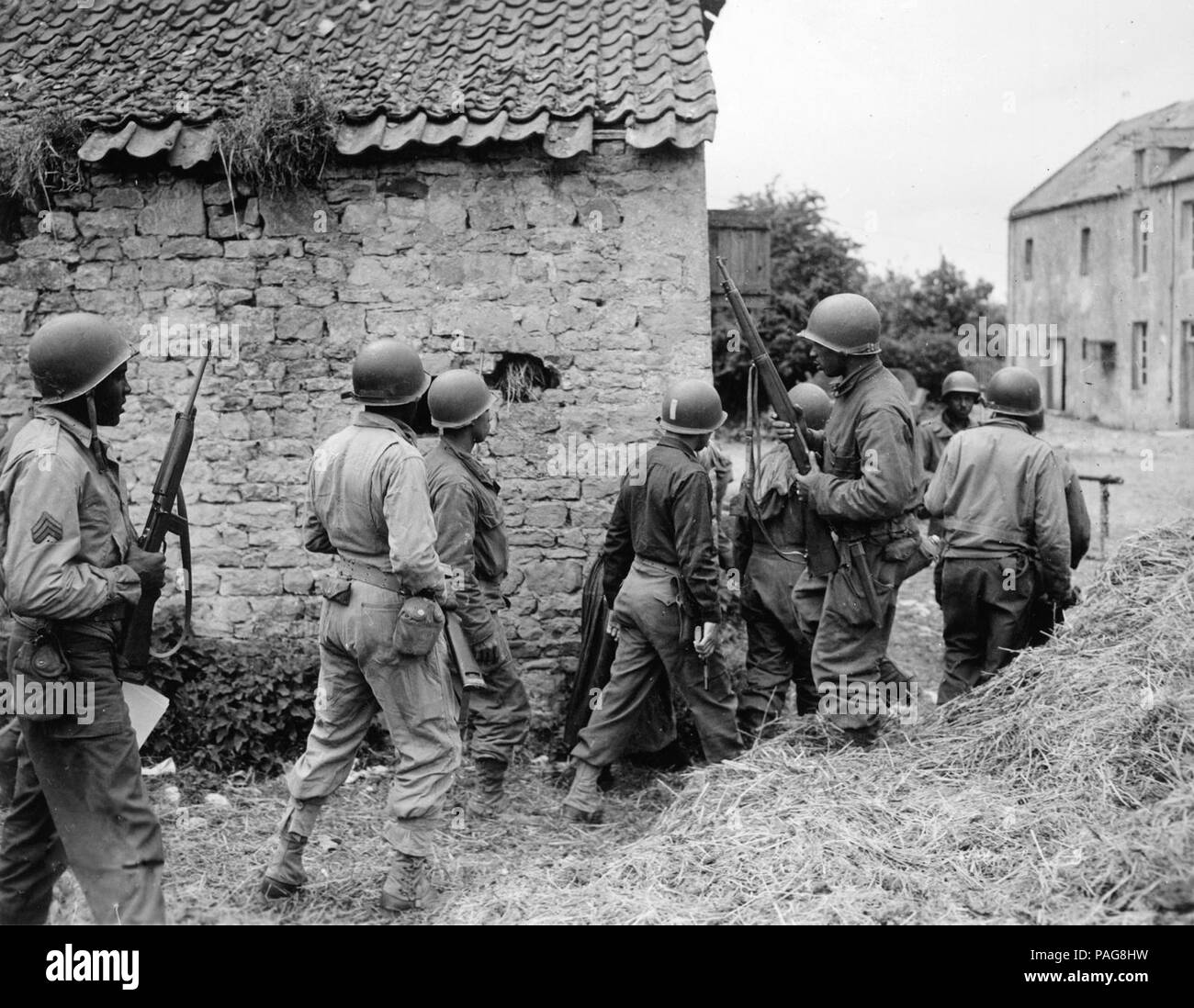 A platoon of Negro troops surrounds a farm house in a town in France ...
