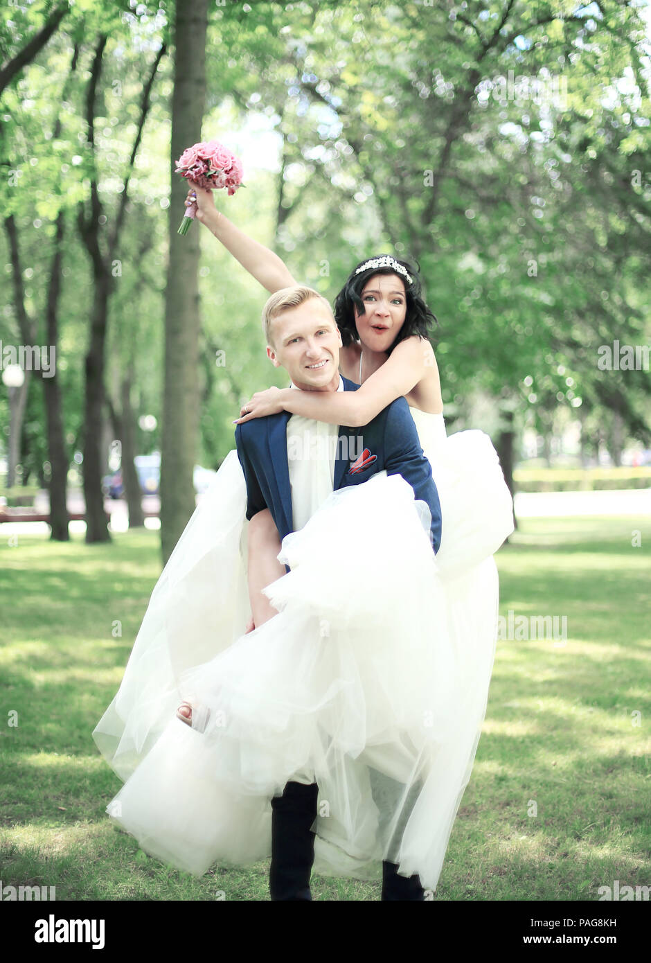 happy groom carrying his bride in his arms Stock Photo - Alamy