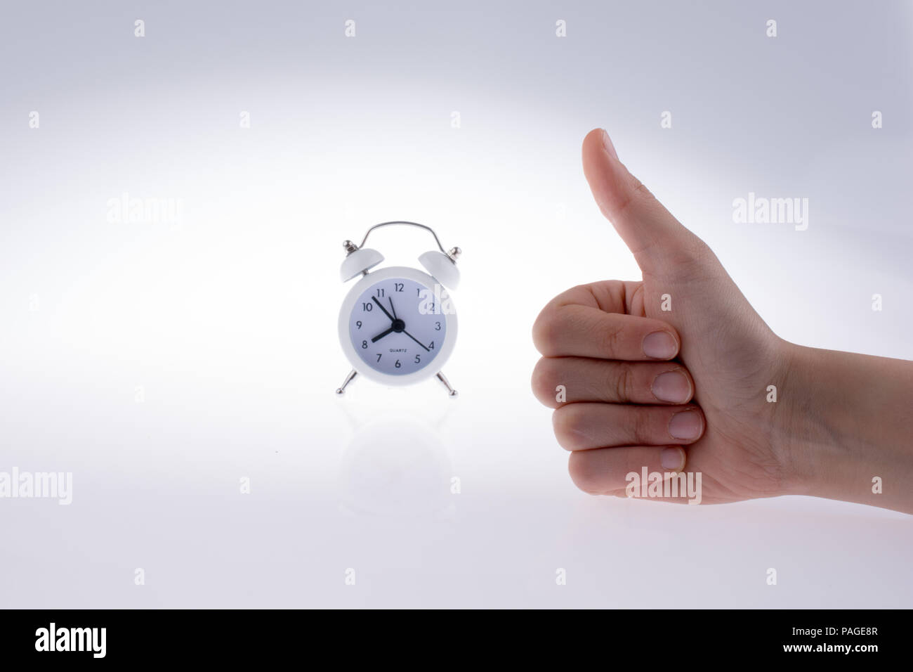Alarm clock in hand on a white background Stock Photo - Alamy