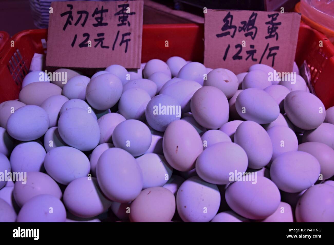 Fresh hen eggs heaped up inside the plastic basket. Translation: "hen ...