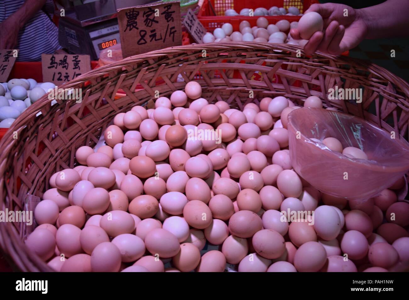 Fresh hen eggs heaped up inside the wicker basket. Translation: "hen ...