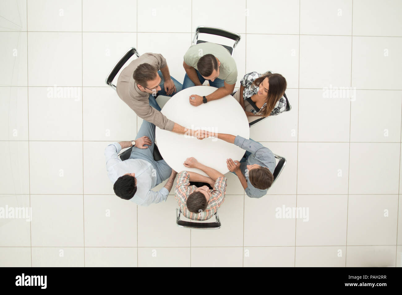 top view. handshake colleagues at the round table Stock Photo - Alamy
