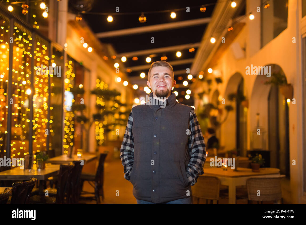 Young smiling guy posing at night in cafe Stock Photo - Alamy