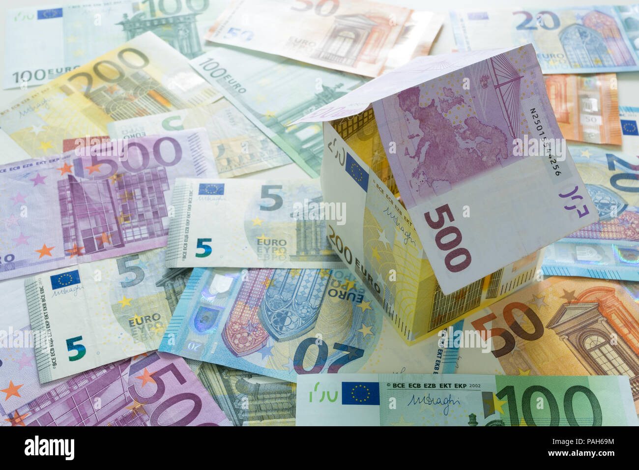Euro house on euro banknotes background Stock Photo - Alamy