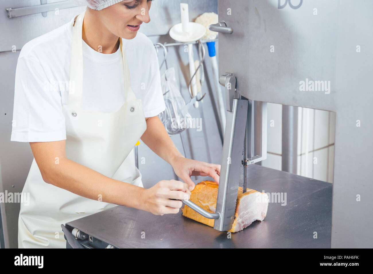 Butcher woman using saw to cut meat in her butchery Stock Photo - Alamy