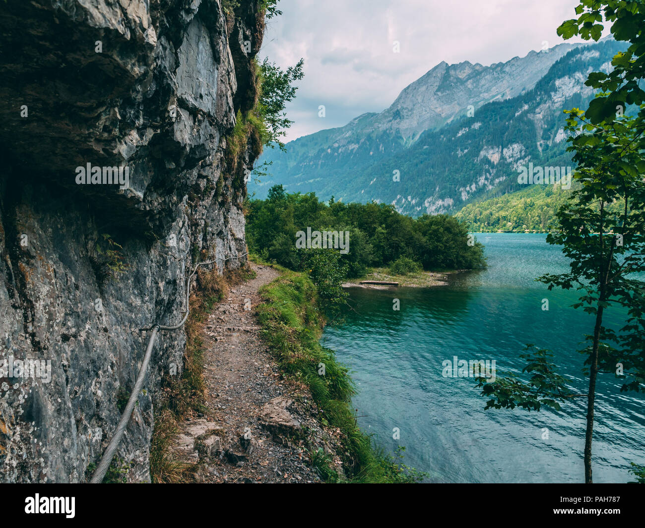 dangerous mountain path at a lake in the swiss alps, hiking ...