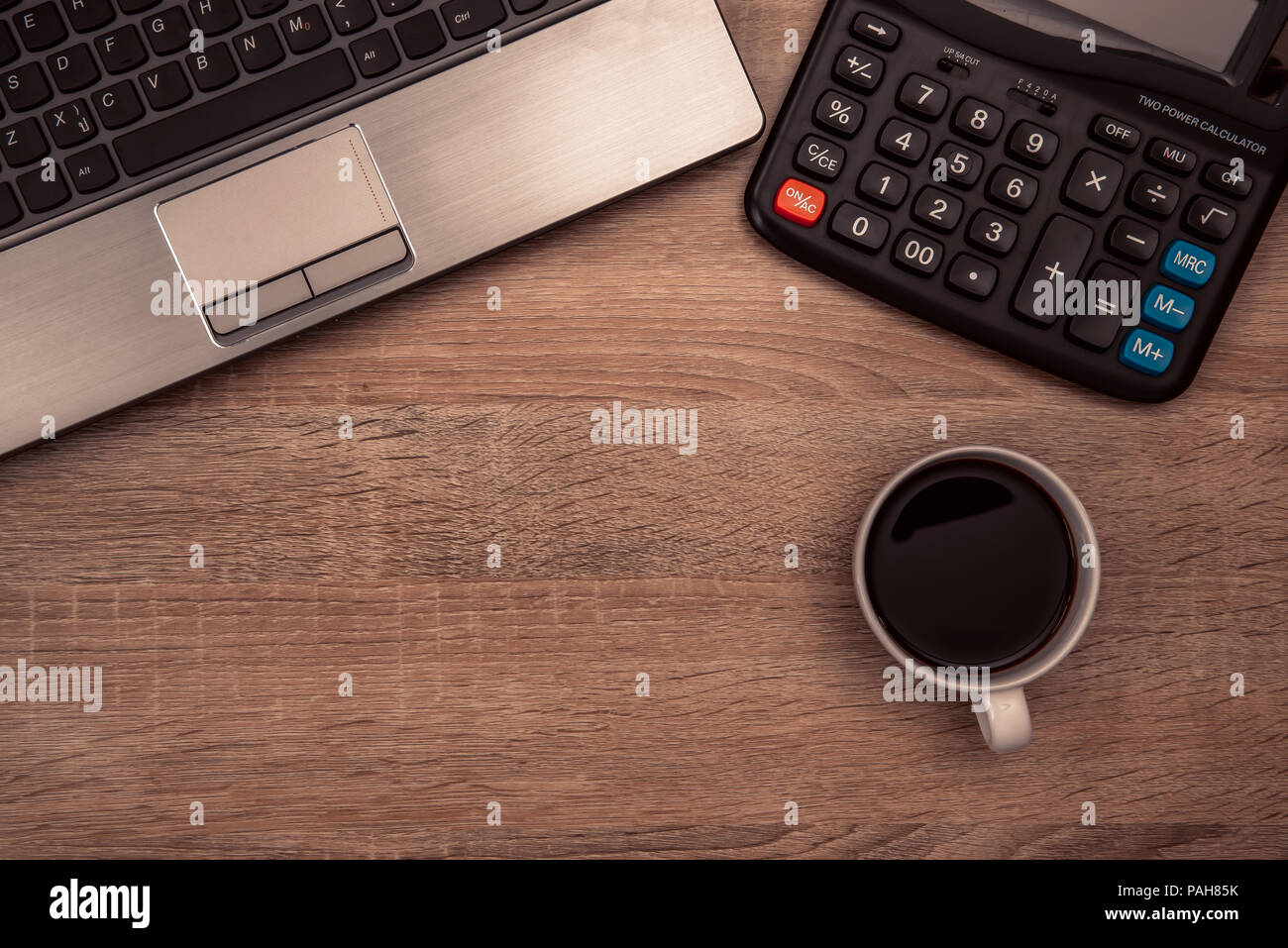 Laptop computer or notebook, calculator and cup of coffee on working ...