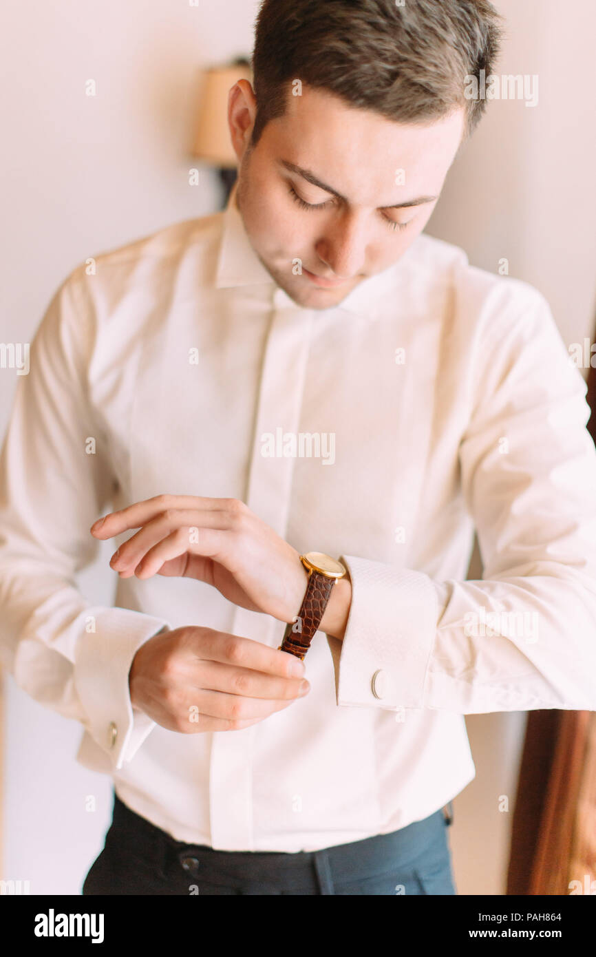 The groom is putting the hand watch on his hand Stock Photo - Alamy
