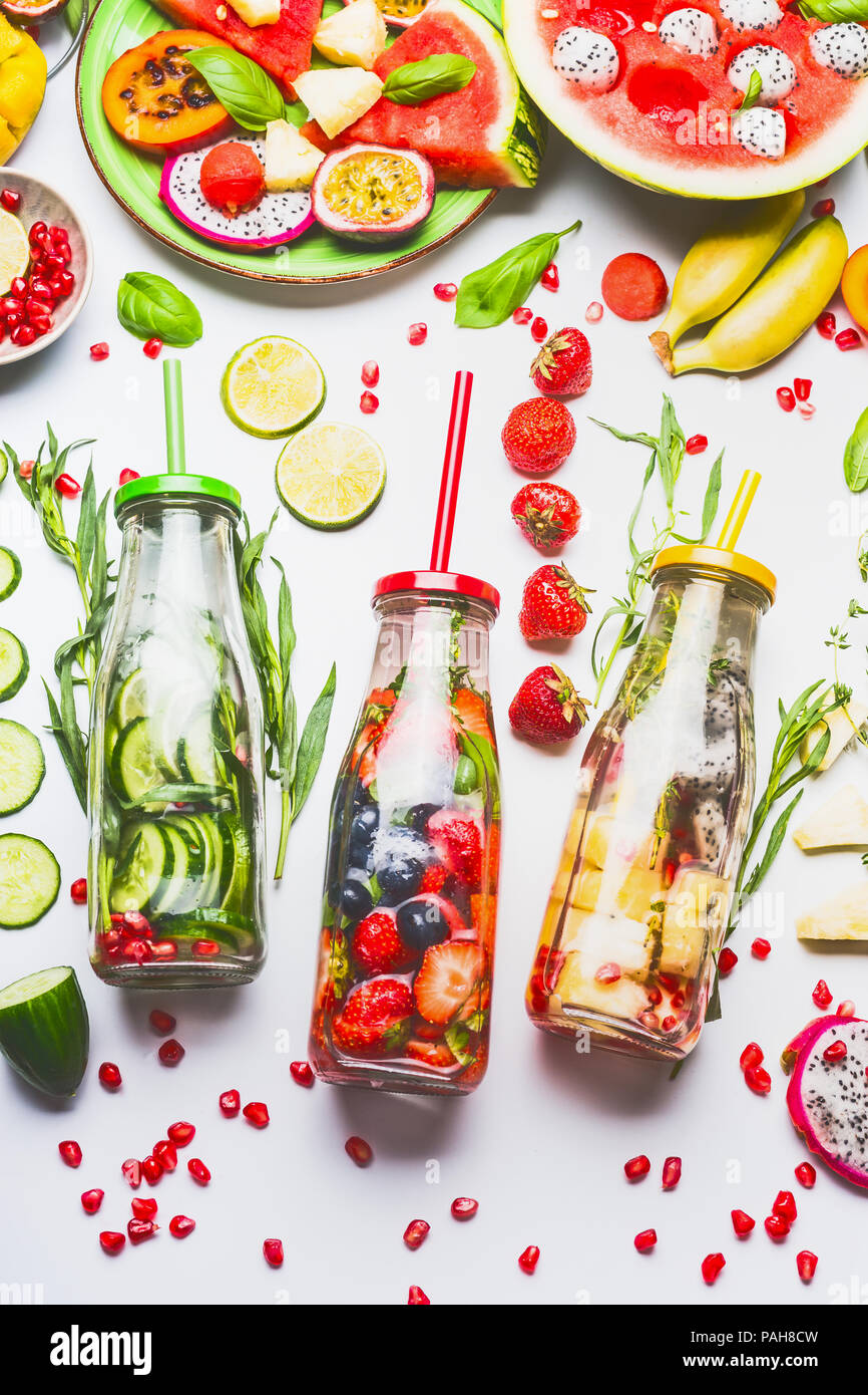 Infused water in bottles with fresh fruits, vegetables and herbs on ...
