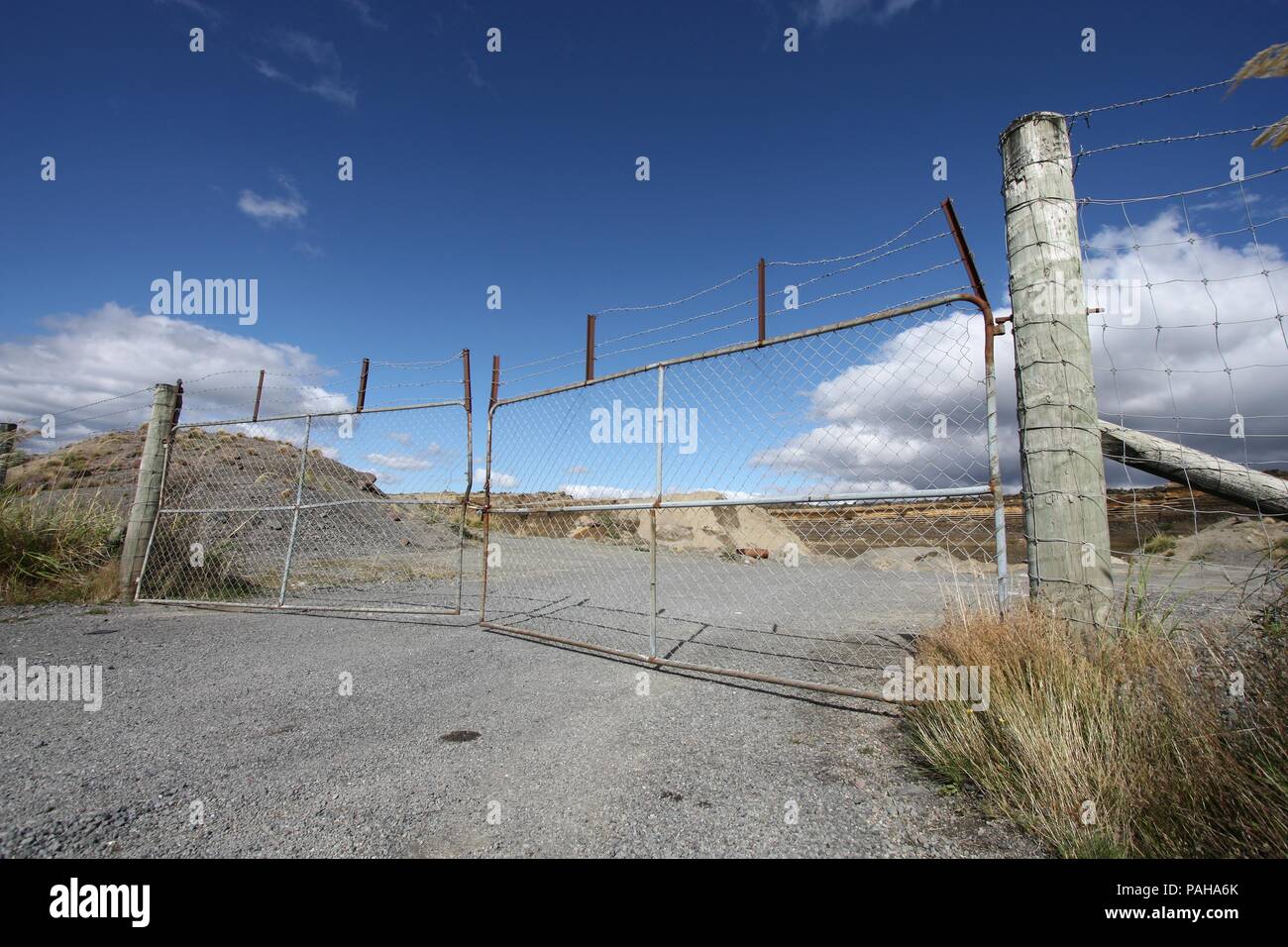 Quarry entrance - old steel gate with barbed wire Stock Photo - Alamy