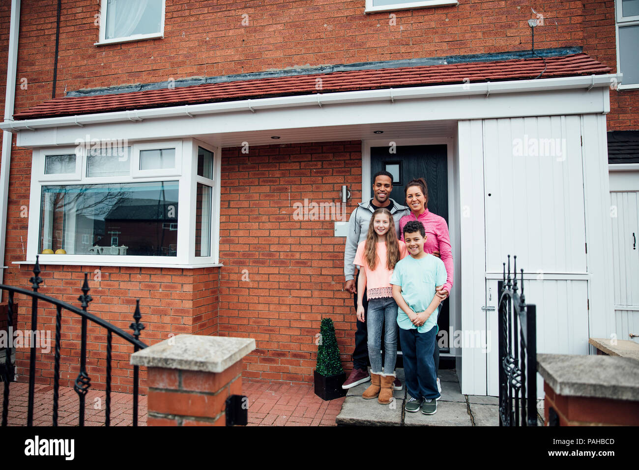 Portrait of a multi-ethnic family at the front door of their home Stock ...