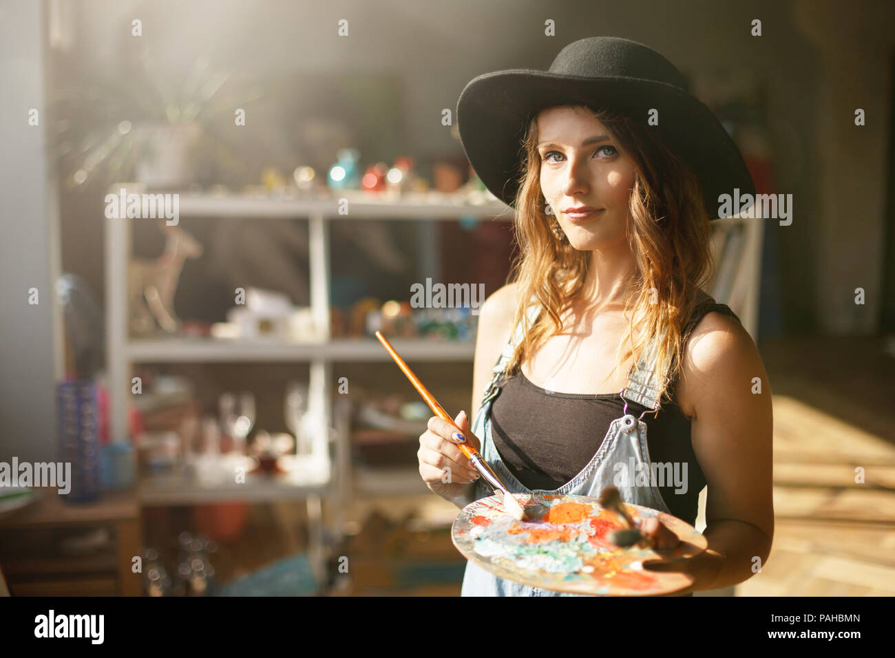 Portrait of handsome long-hair female artist in cute black hat mixed ...