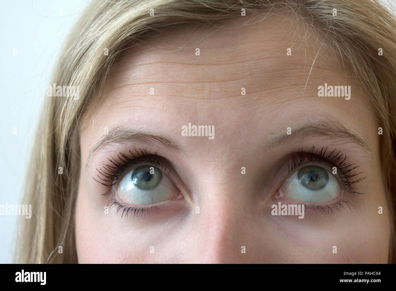 blond young woman eyes looking up Stock Photo - Alamy
